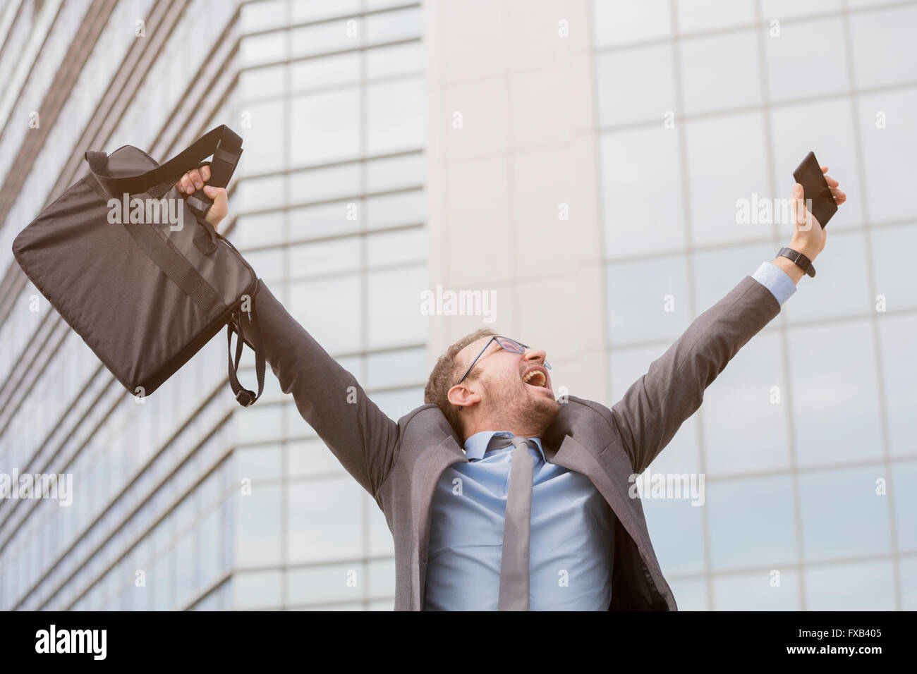 Young professional celebrating his success with hands up Stock Photo ...