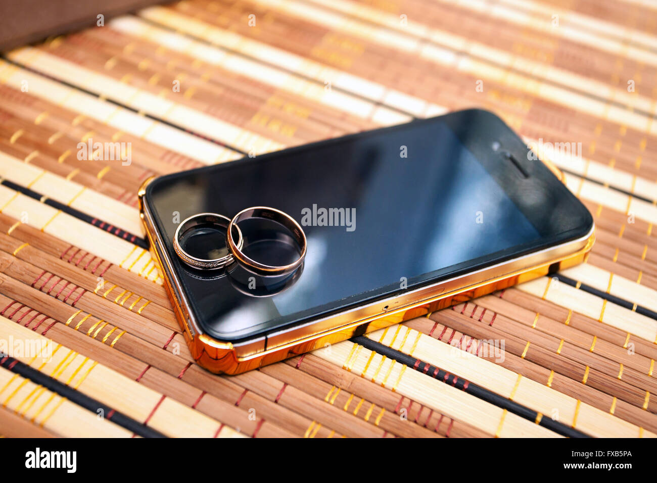 wedding rings on the display of expensive mobile phone Stock Photo - Alamy