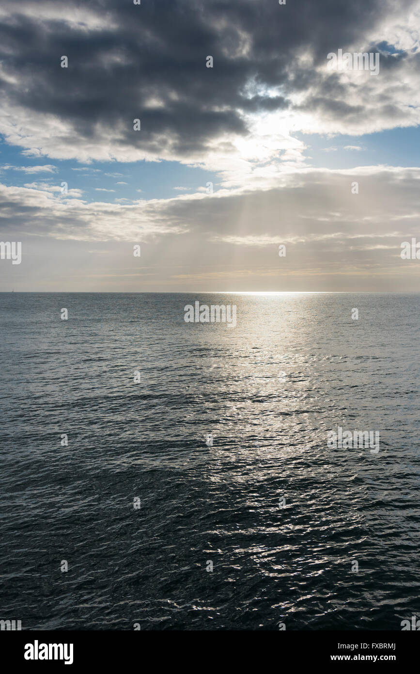 A seascape in the English Channel UK with sun rays appearing from ...