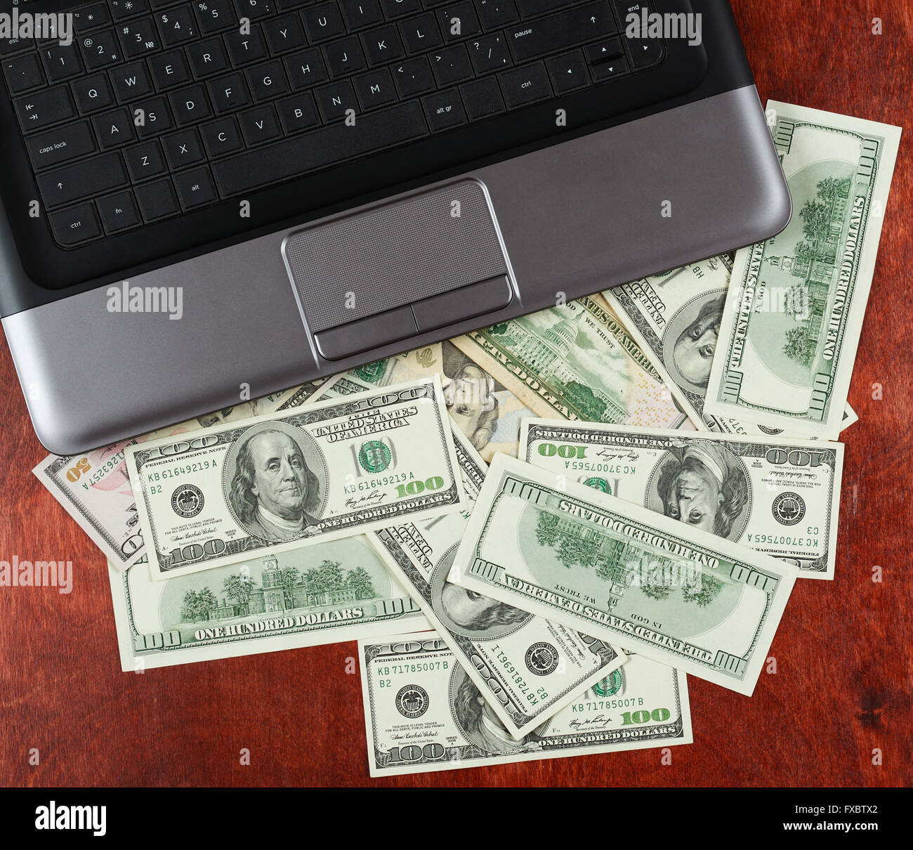 Money dollar currency and notebook computer on wood background ...