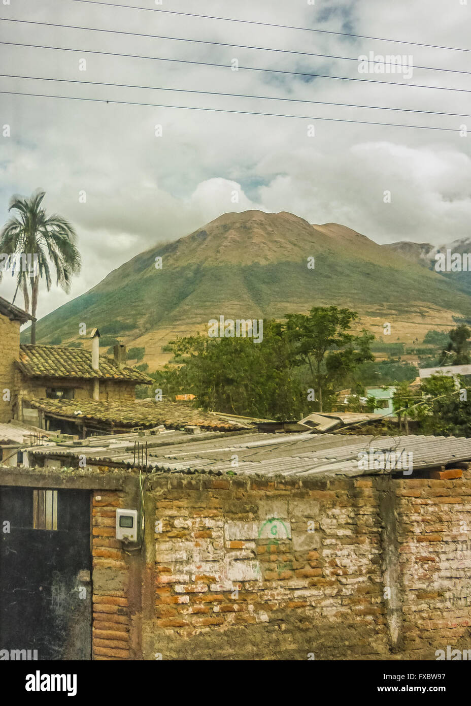 Landscape rural scene of poor houses and big mountains at background ...