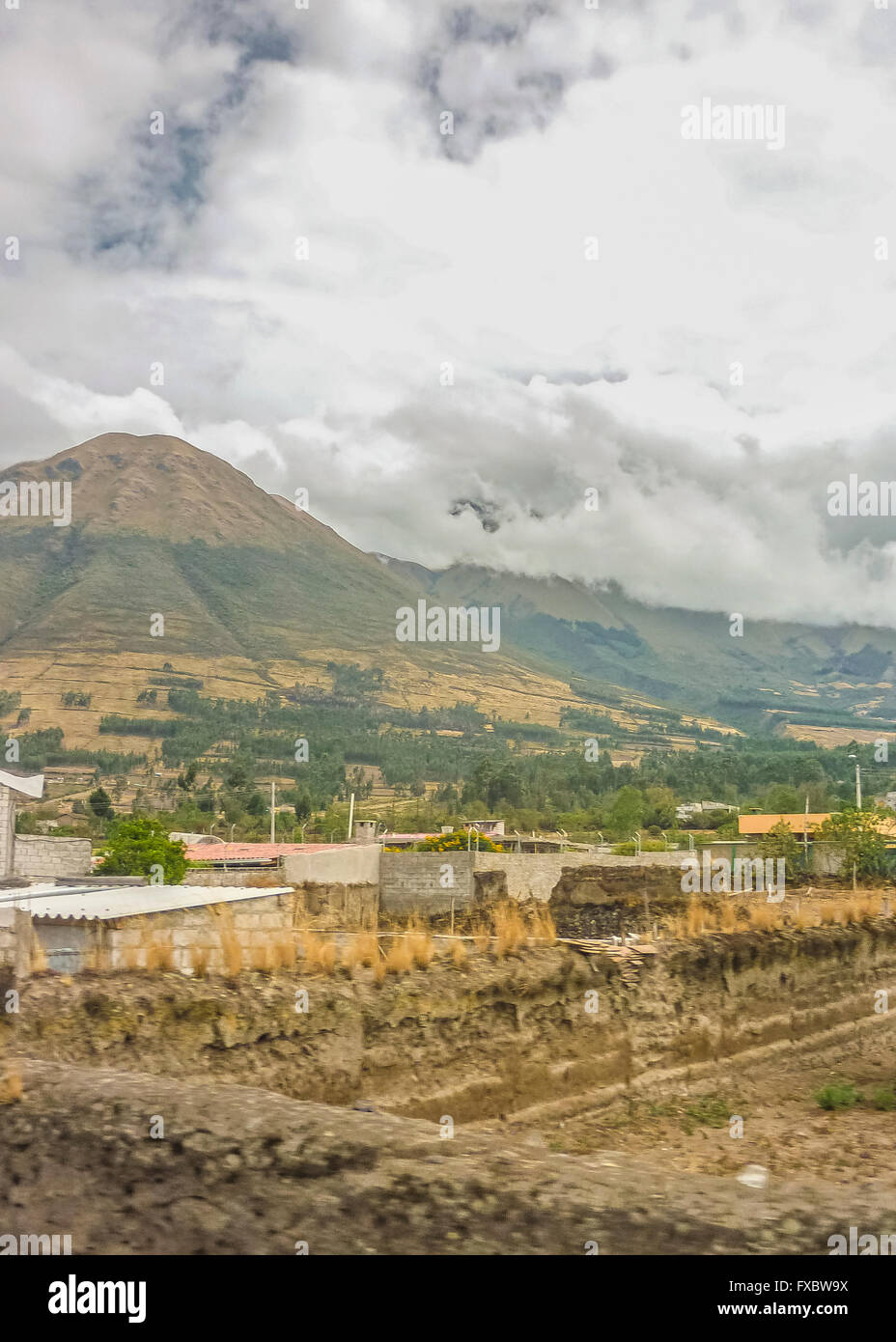 Landscape rural scene of poor houses and big mountains at background ...