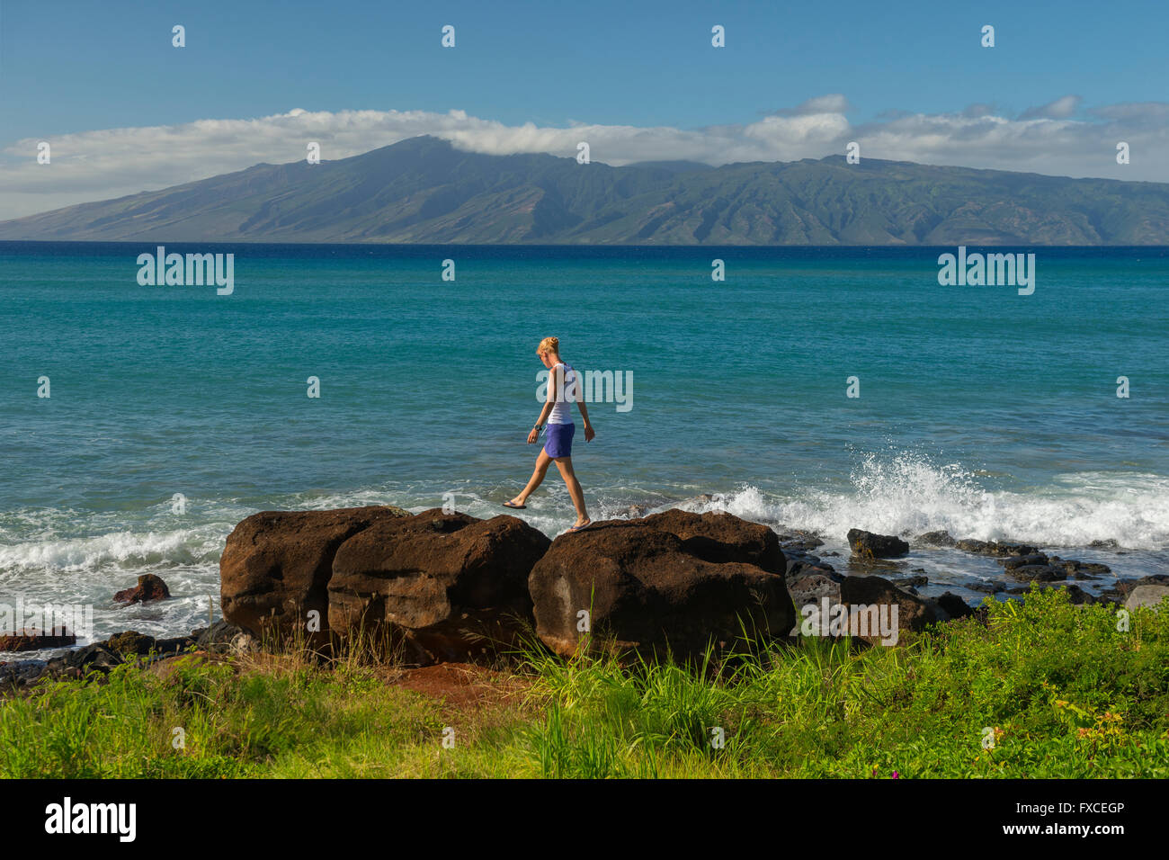 USA, Hawaii, Maui, Kaanapali, girl walking on cliffs with island of ...