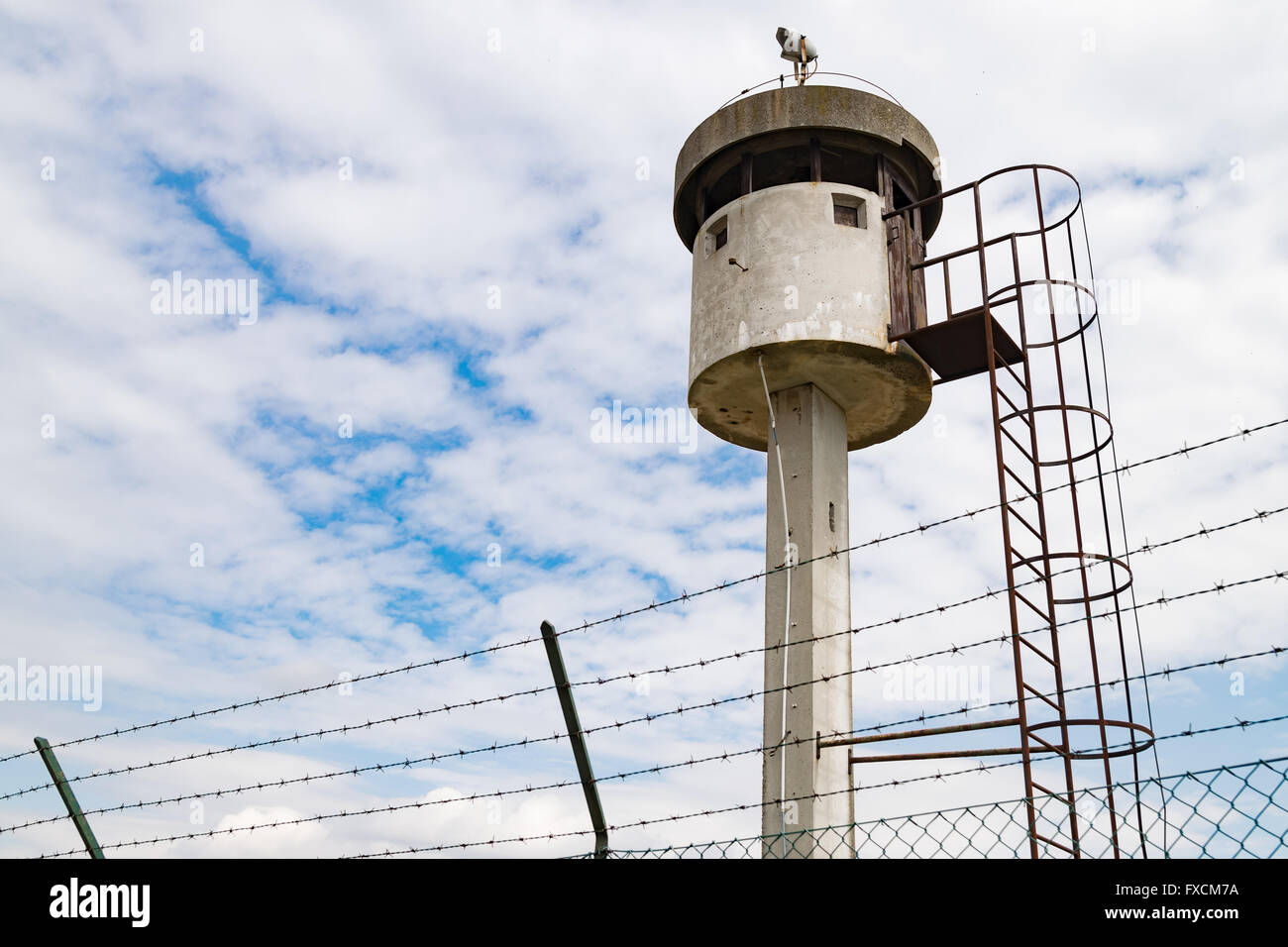 Abandoned watchtower isolated by a net topped with barbed wire Stock ...
