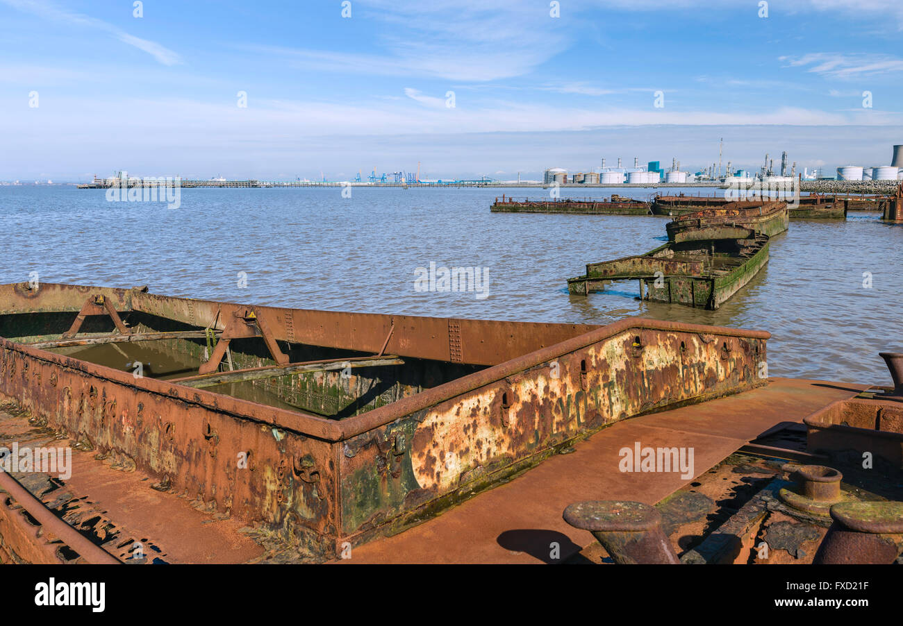 Rusting, obsolete, and abandoned river boats beached on the mud banks of the Humber estuary at ...