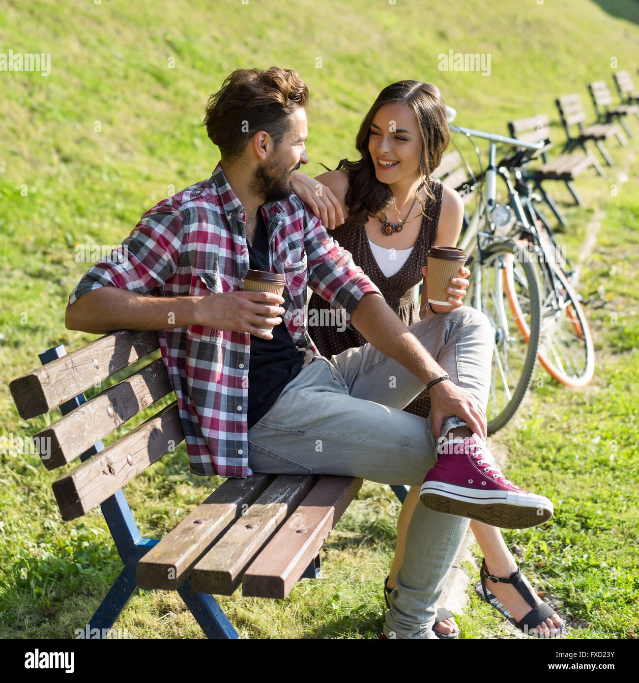 people drinking coffee in a relaxing day in park on a bench, having ...