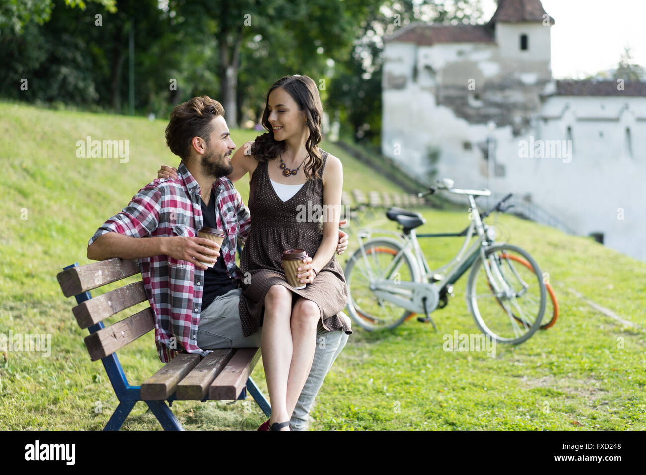 people drinking coffee in a relaxing day in park on a bench, having ...