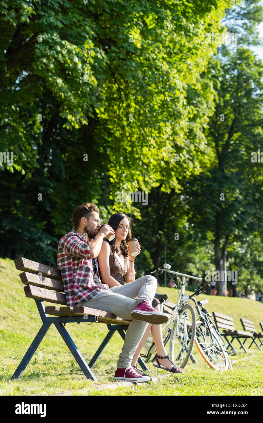 people drinking coffee in a relaxing day in park on a bench, having ...