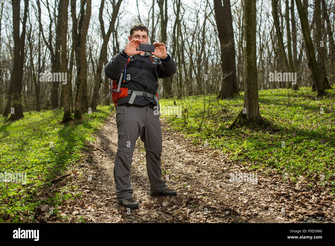Man hiker taking photo with smart phone in forest Stock Photo - Alamy