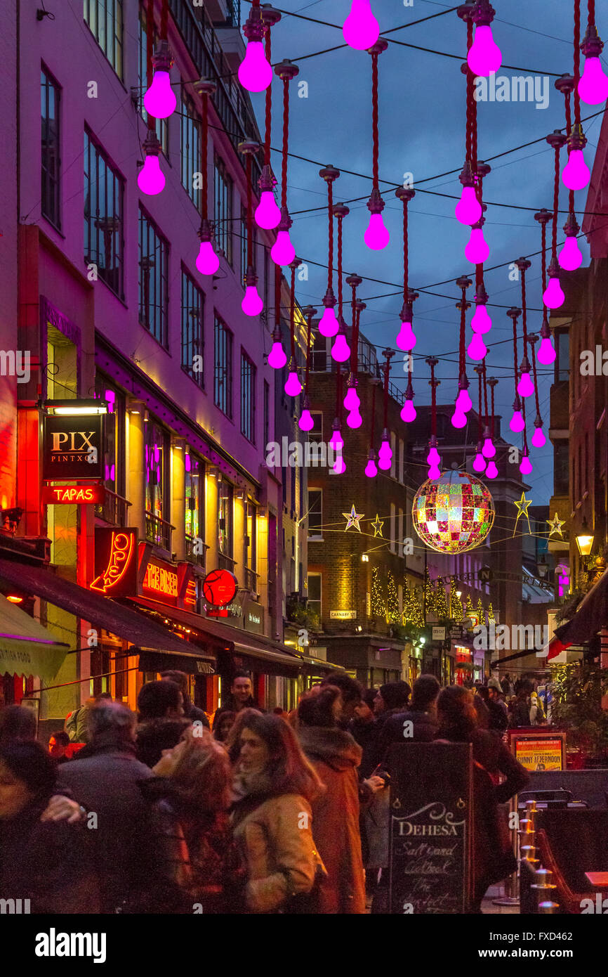 Giant illuminated purple light bulbs hanging from wires above Ganton St ...
