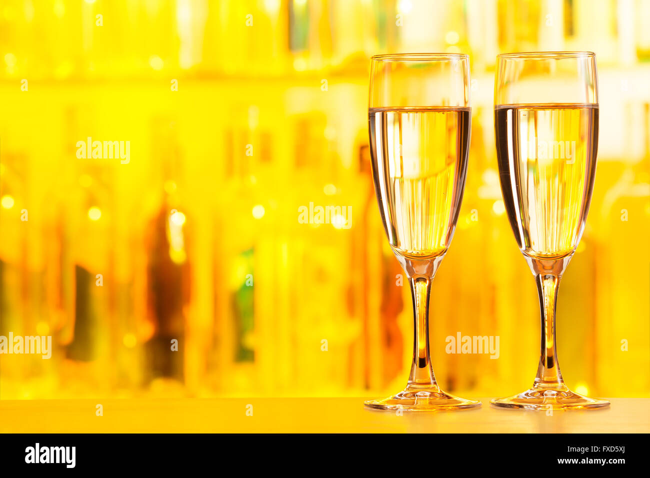 Two full flute glasses standing on bar counter Stock Photo - Alamy