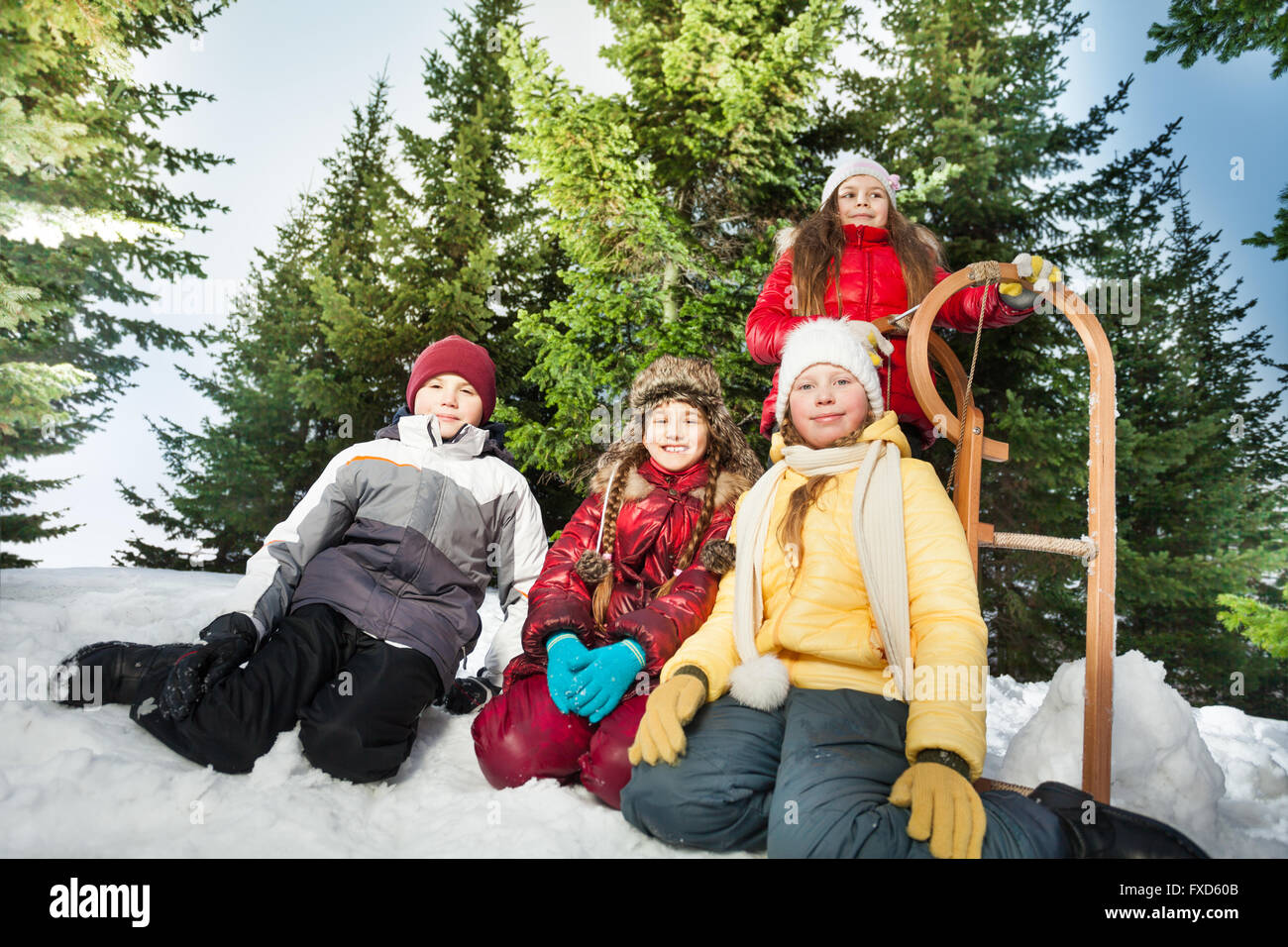 Kids sitting together outside near wooden sledge Stock Photo - Alamy