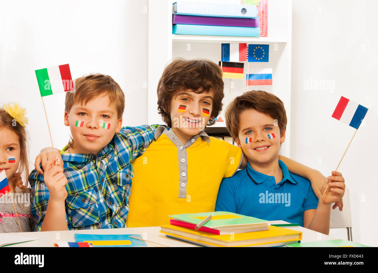 Four kids with banners on cheeks waving flags Stock Photo - Alamy