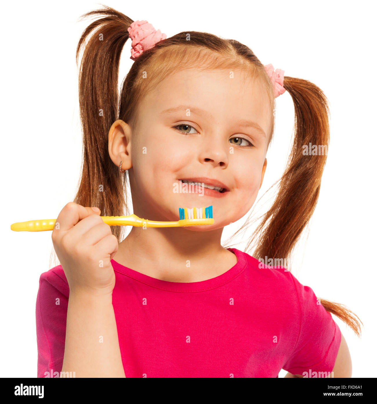 Cute girl brushing teeth with yellow toothbrush Stock Photo - Alamy