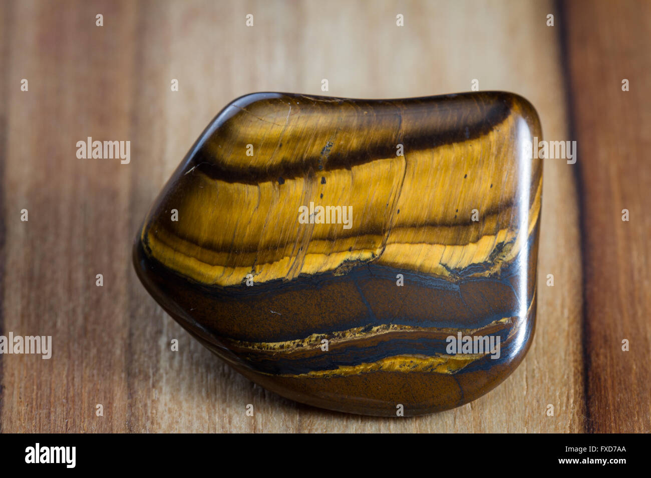 gemstone known as tiger eye or cat eye with a golden color contrasted ...