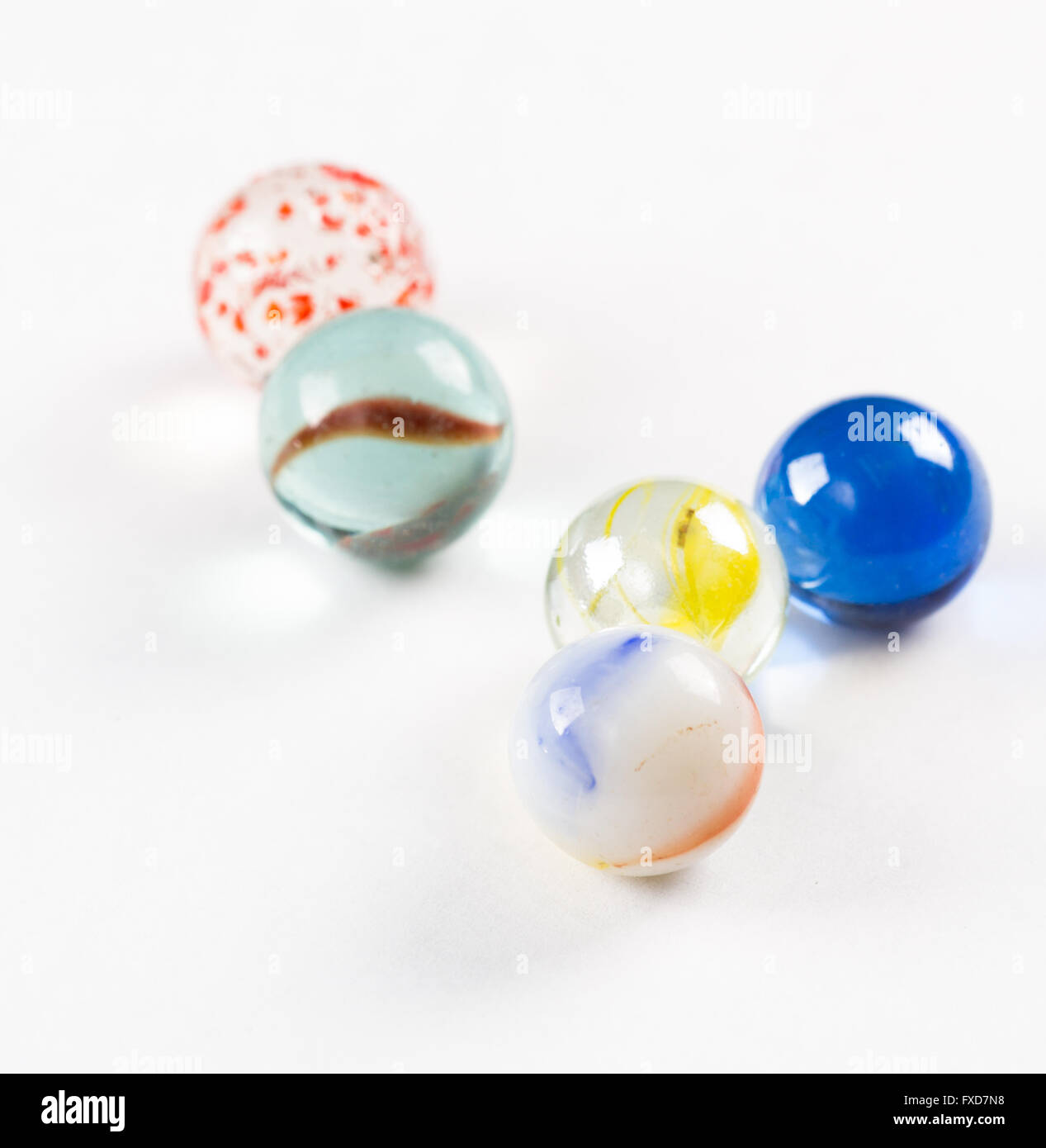 group of marbles in a variety of colors isolated on a white background ...