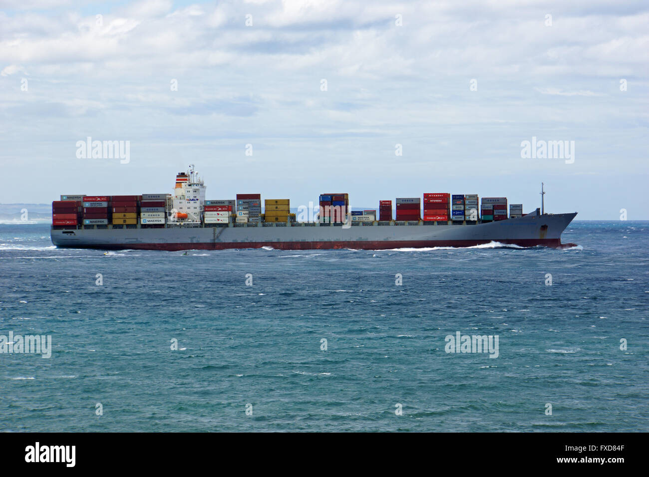Container ship at sea and side view of fully loaded ocean shipping ...