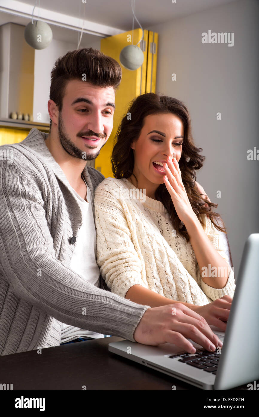 A young couple using in the evening their laptop computers at home ...