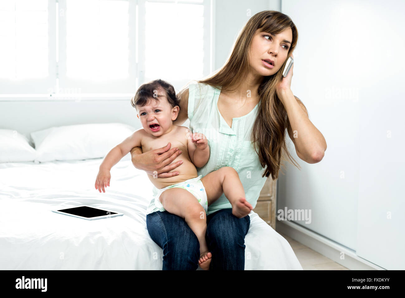 Son crying while mother talking on mobile phone Stock Photo - Alamy