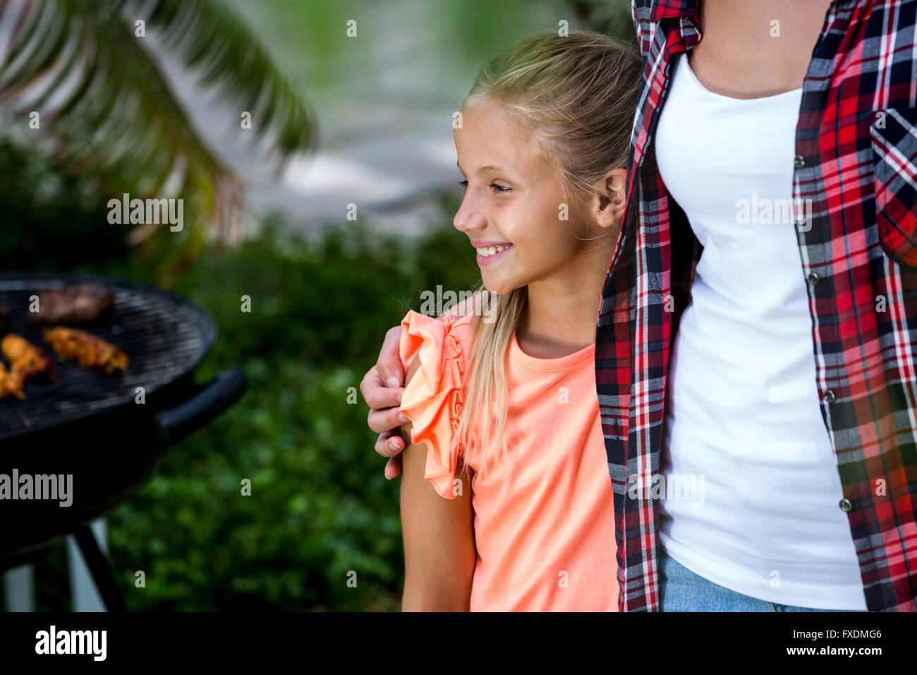Mother with daughter by barbeque grill Stock Photo - Alamy