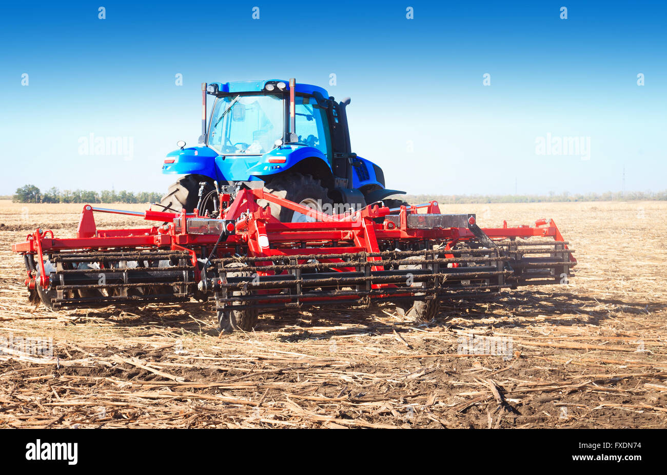 Blue tractor in an open field on a sunny day Stock Photo - Alamy