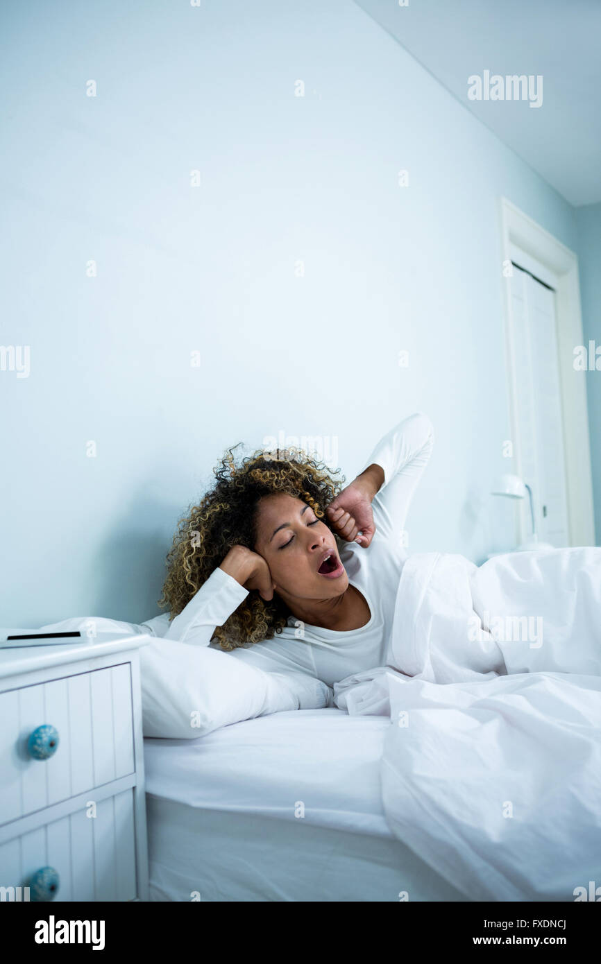 Woman waking up in bed Stock Photo - Alamy
