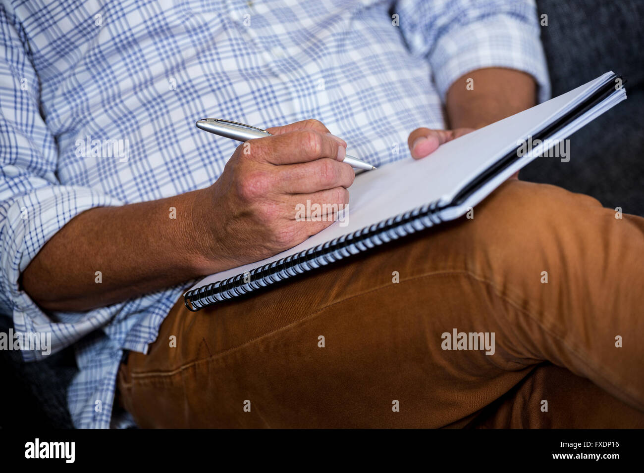 Man writing notes in diary Stock Photo - Alamy