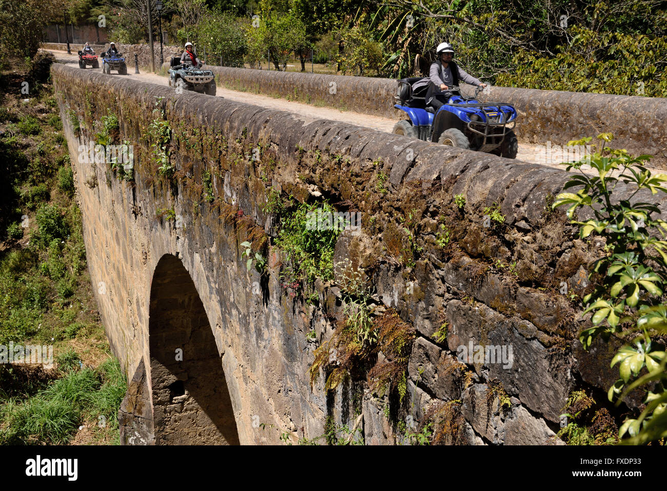 ATVs crossing old stone bridge entering village of San Sebastian del ...