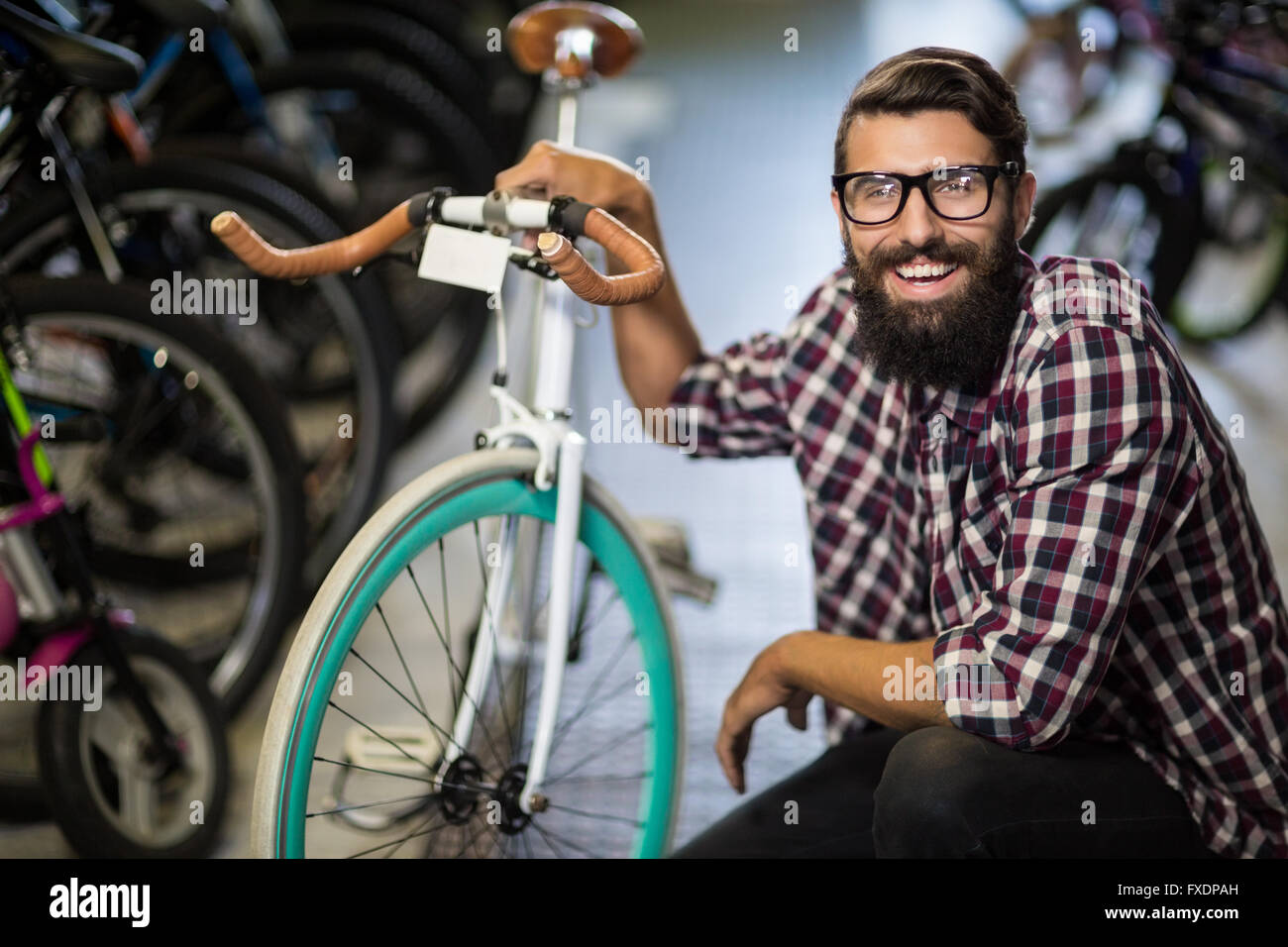 Bike mechanic crouching next to a bicycle Stock Photo - Alamy