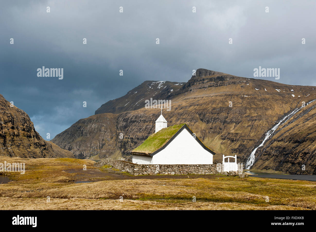 Small church with grass roof in mountain landscape, Saksun, Streymoy ...