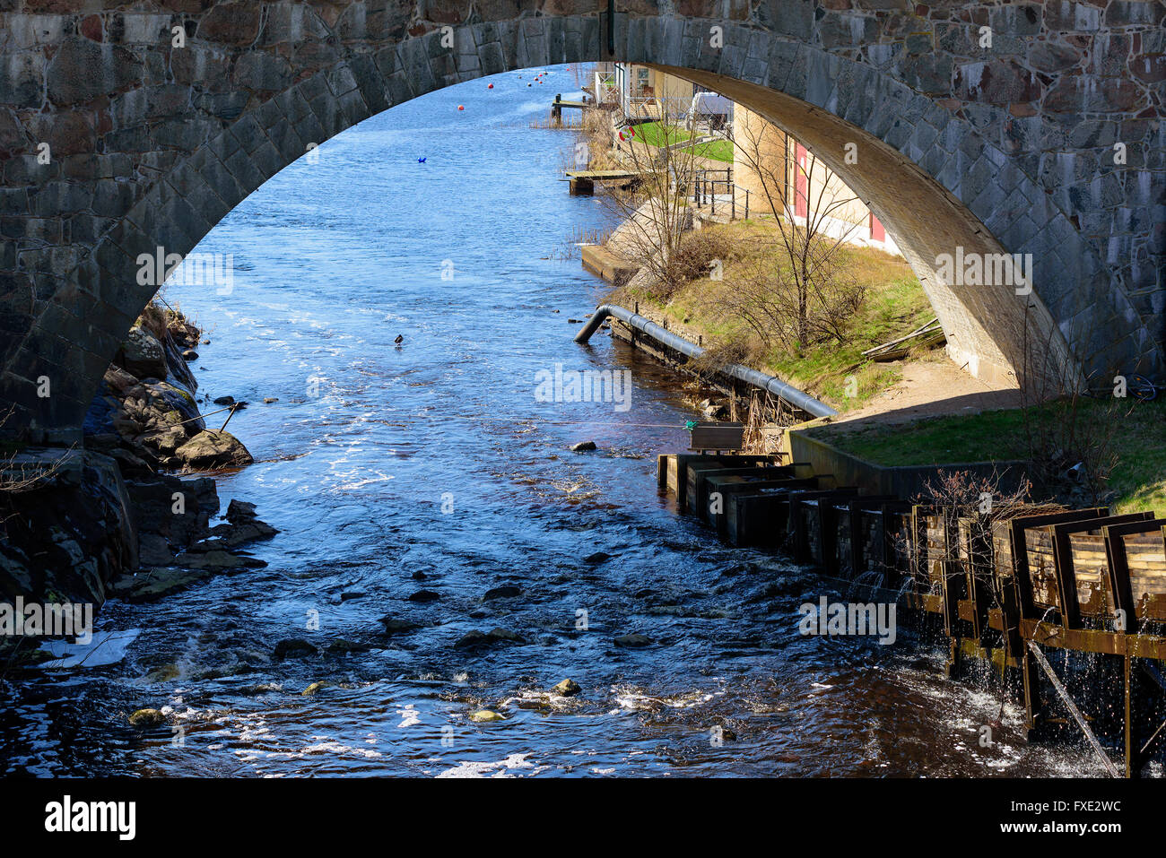 The Lyckeby river flows under a stone bridge. A fish ladder and part of ...