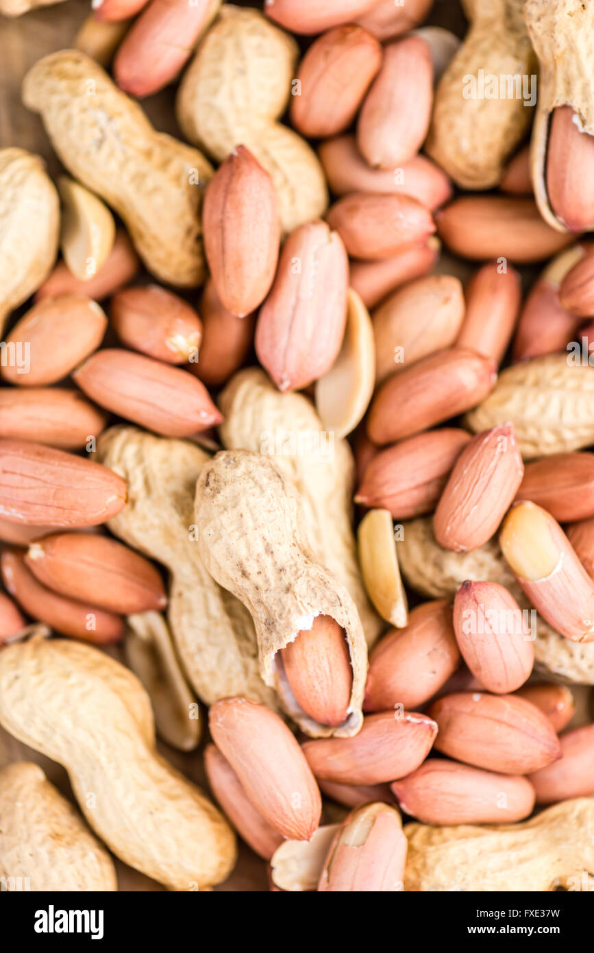 Portion of Peanut Seeds on rustic background (selective focus; close-up ...