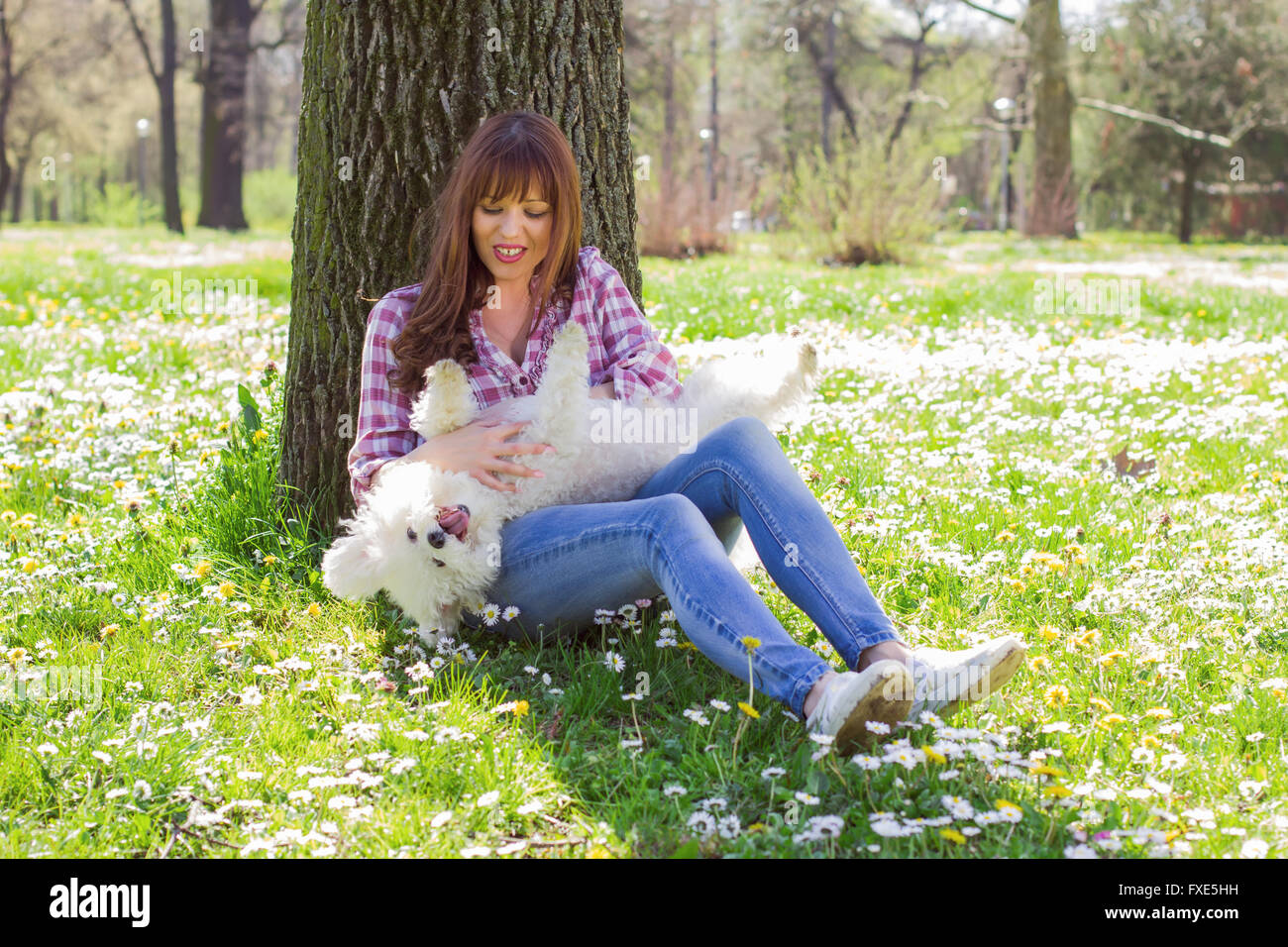 Happy beautiful young woman, enjoying nature with her dog, at sunny ...