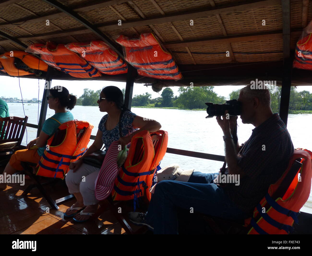Passenger ferry with basket of fruit carrying tourists around Mekong ...