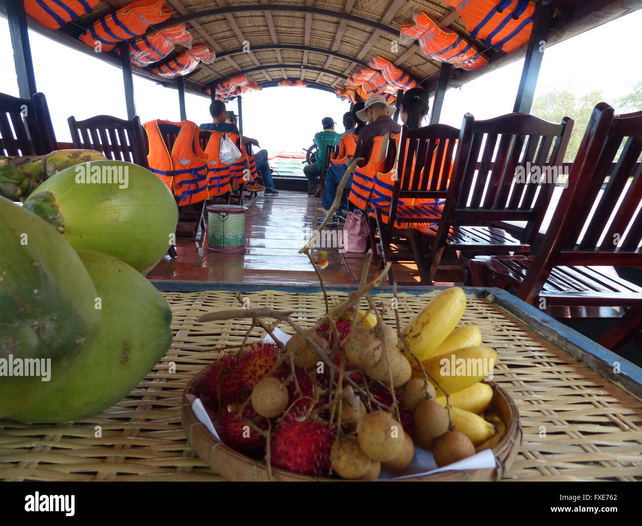 Passenger ferry with basket of fruit carrying tourists around Mekong ...