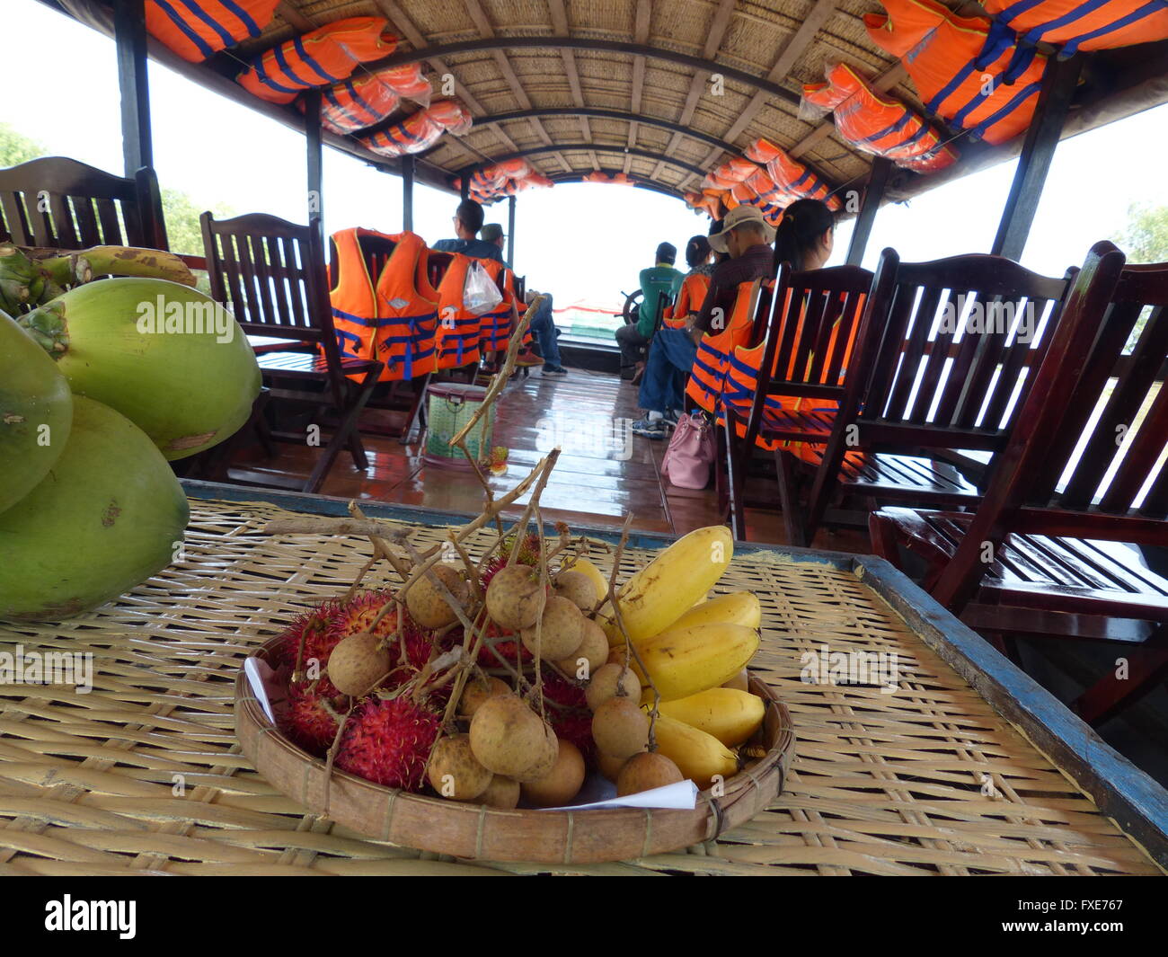 Passenger ferry with basket of fruit carrying tourists around Mekong ...