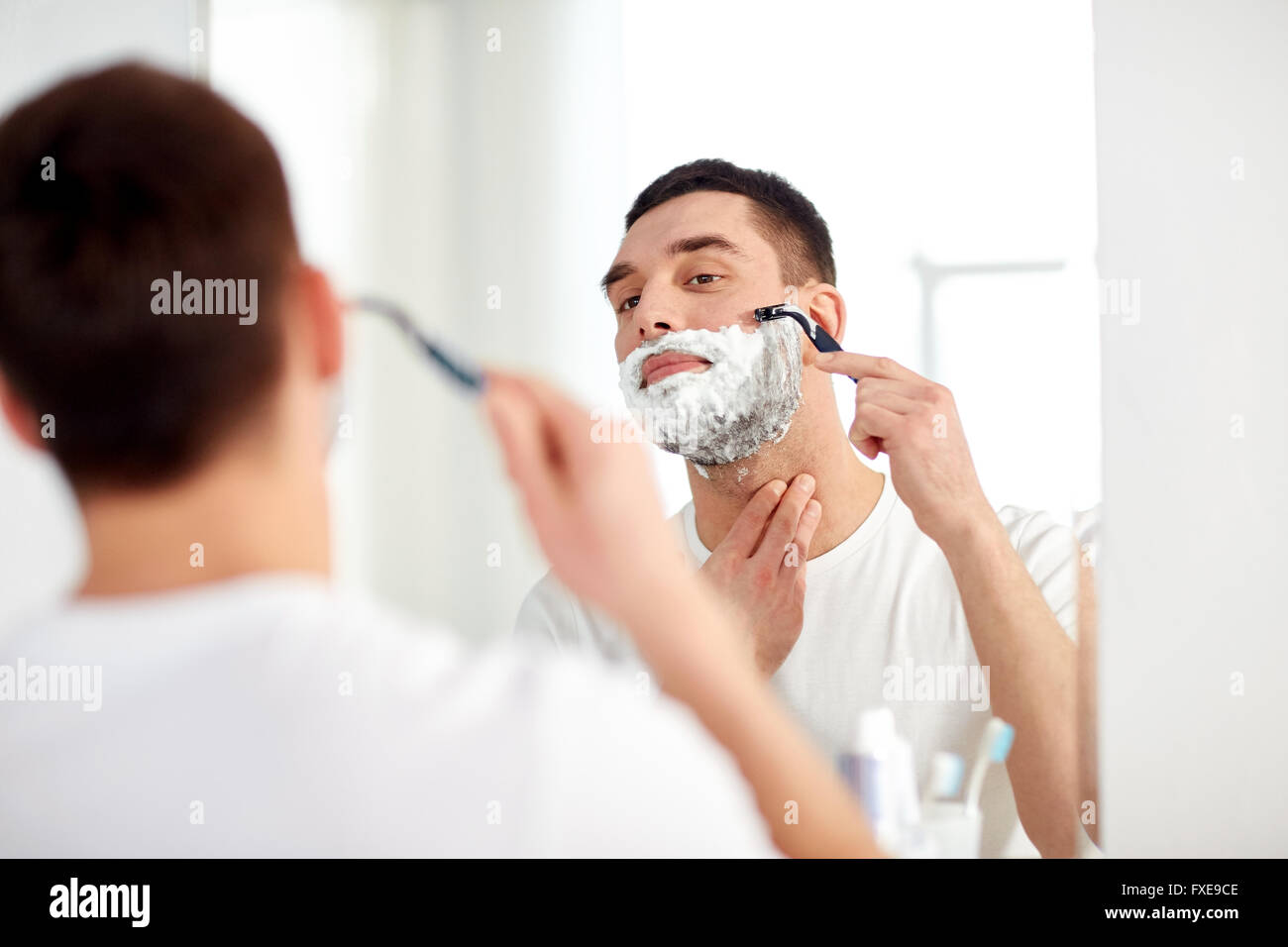 man shaving beard with razor blade at bathroom Stock Photo - Alamy