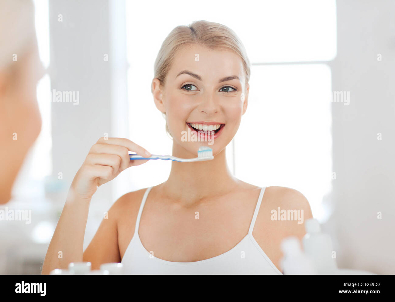 woman with toothbrush cleaning teeth at bathroom Stock Photo - Alamy