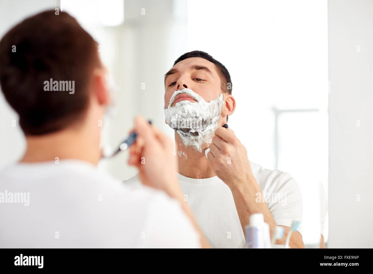 man shaving beard with razor blade at bathroom Stock Photo - Alamy