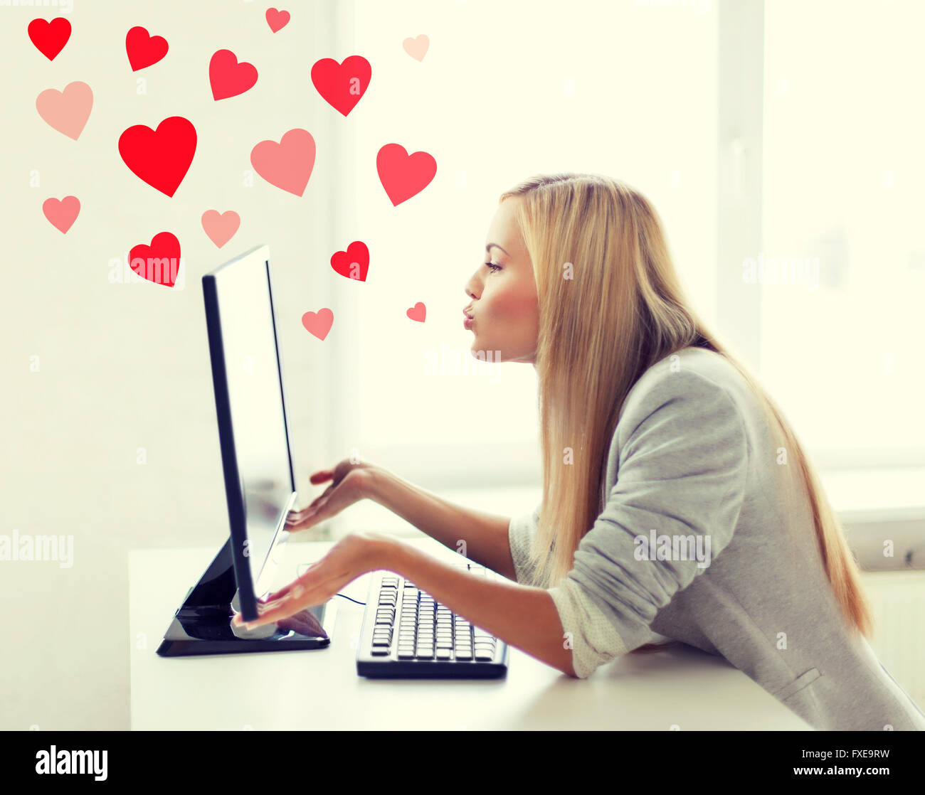 woman sending kisses with computer monitor Stock Photo - Alamy