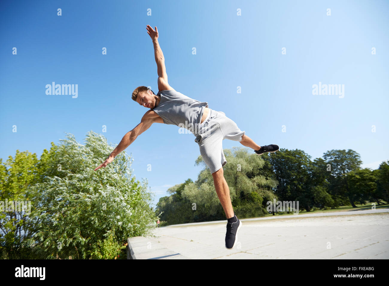 sporty young man jumping in summer park Stock Photo - Alamy