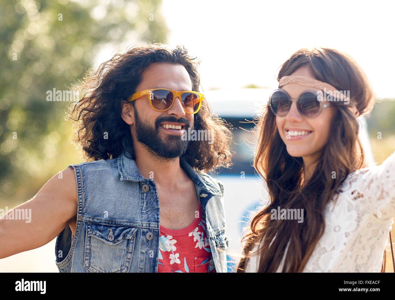 smiling young hippie couple over minivan car Stock Photo - Alamy