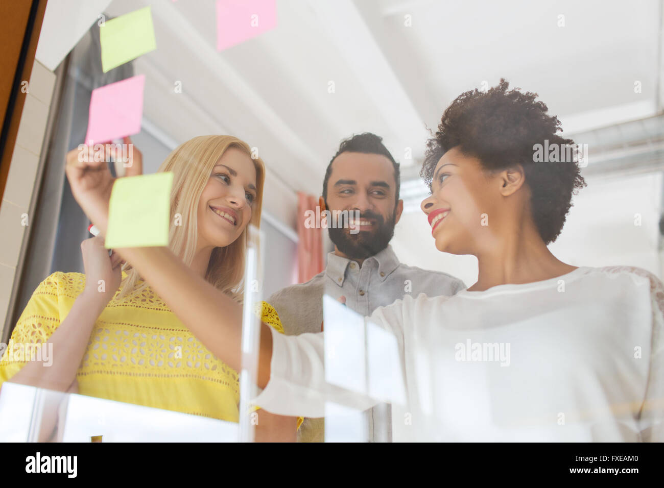 happy creative team writing on stickers at office Stock Photo - Alamy