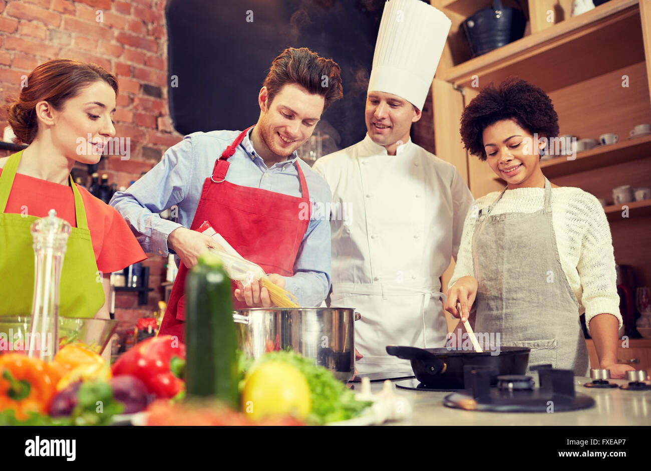 happy friends and chef cook cooking in kitchen Stock Photo - Alamy