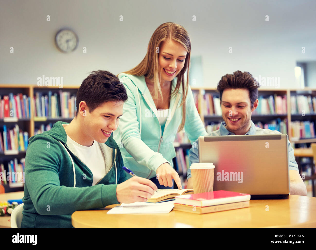 happy students with laptop and books at library Stock Photo - Alamy