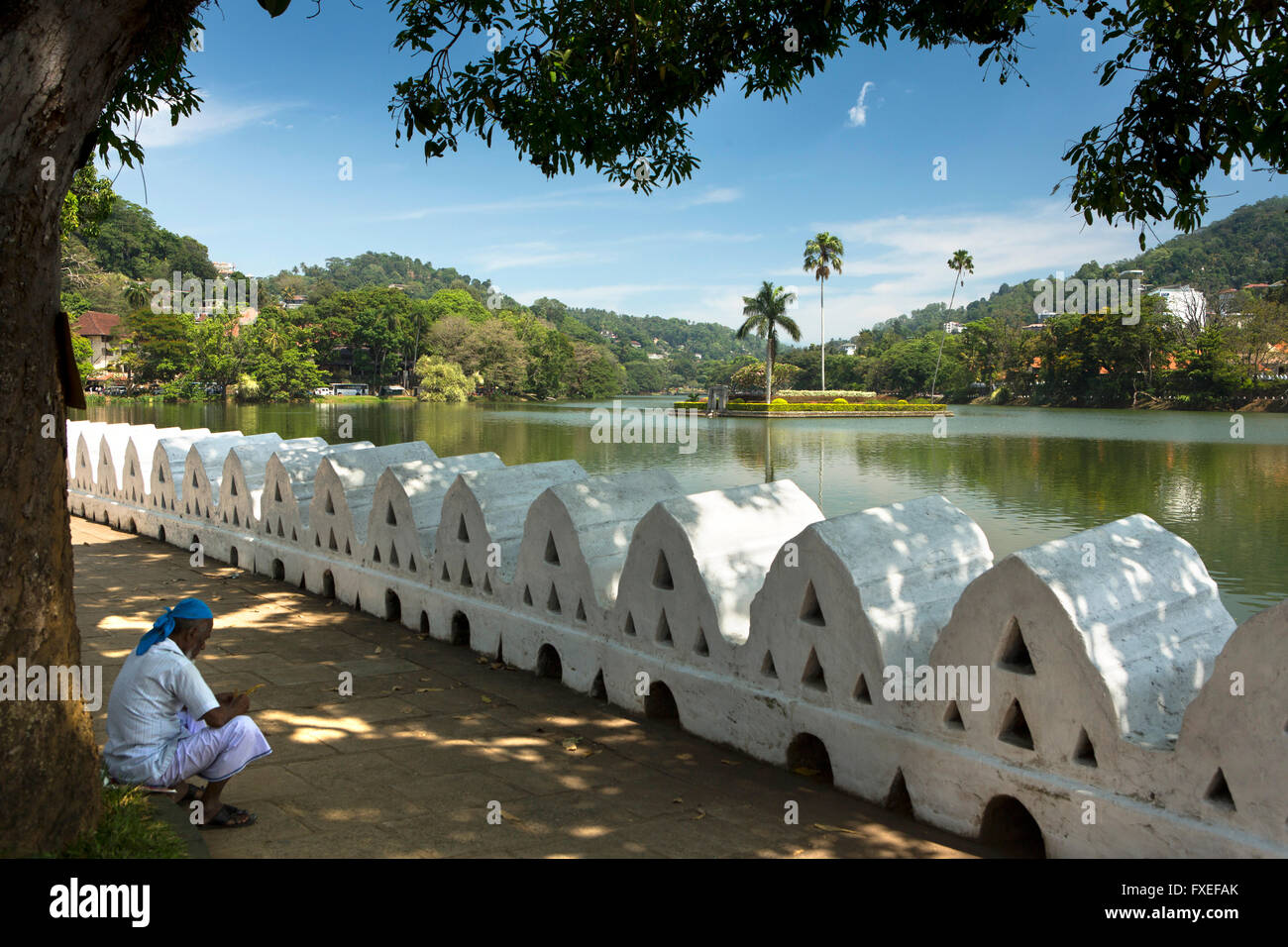 Sri Lanka, Kandy, Dalada Vidiya, man sat in shade beside Kiri Muhuda ...