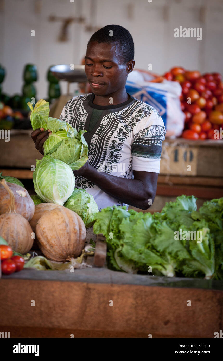 Mozambique, Africa, a man selling vegetables at the market in the city ...