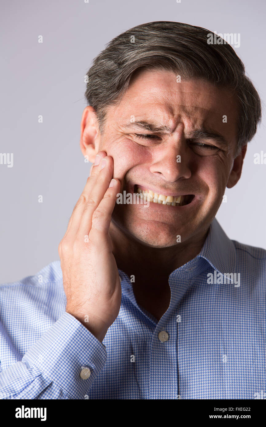 Studio Portrait Of Man Suffering With Toothache Stock Photo - Alamy