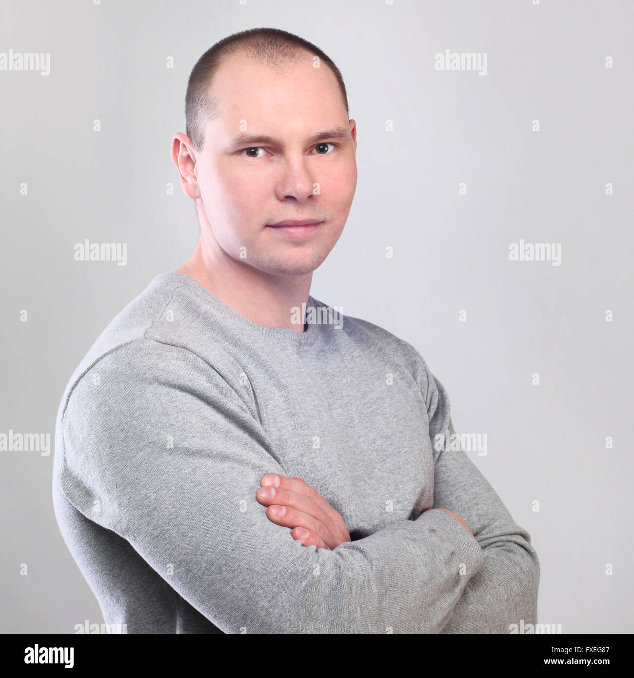 Young man standing confidently gray background Stock Photo - Alamy