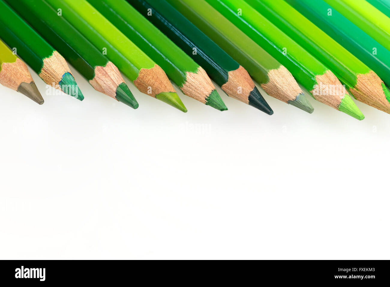 Crayons of different shades of green with copy space are lying in the ...